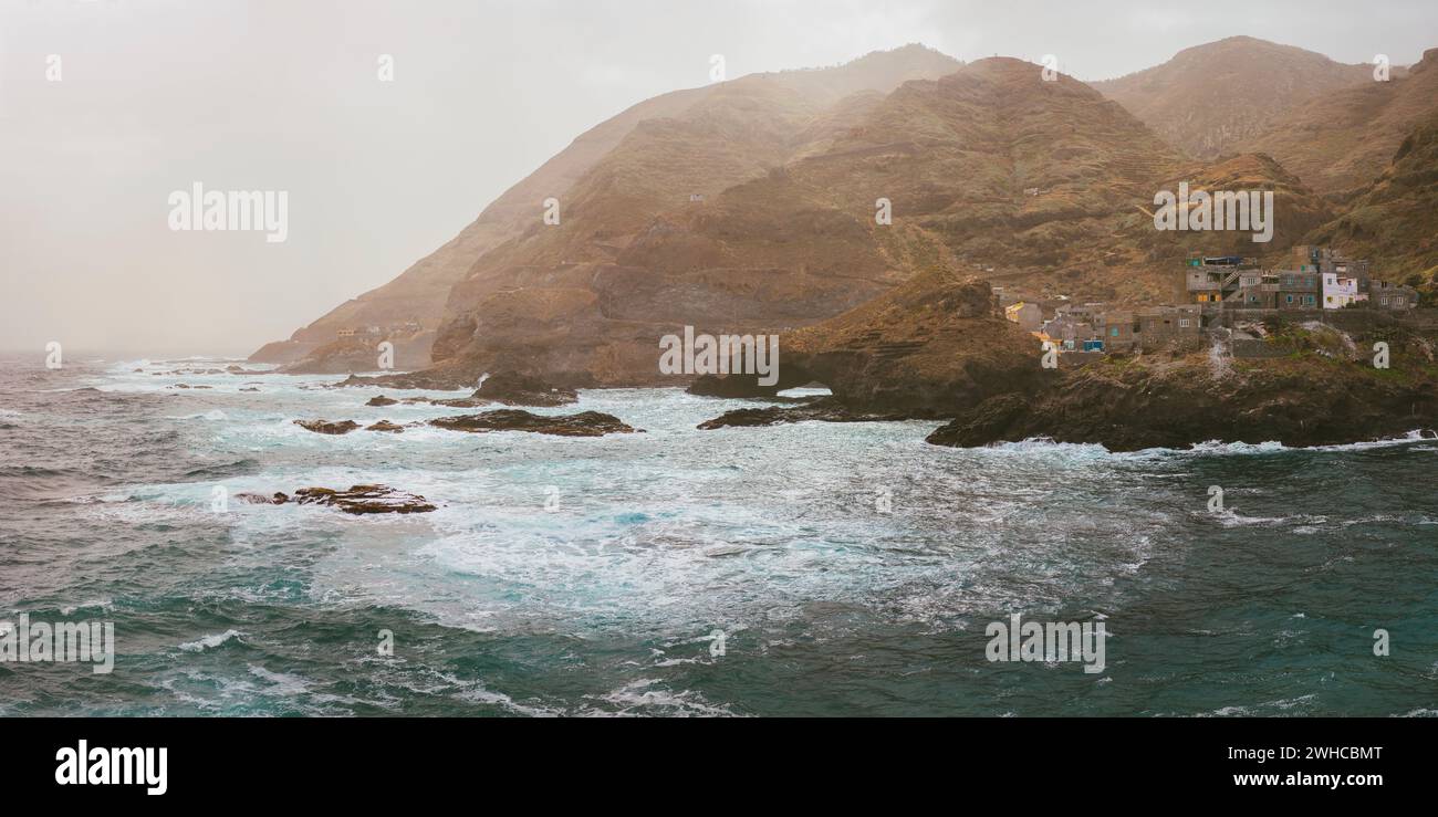 Bluff volcanic coast line. Sunlight penetrates dust and fall over sea ...
