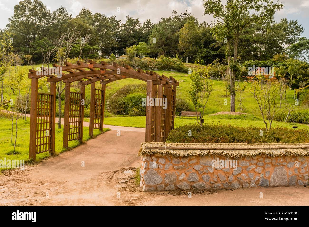 Wooden trellises over concrete walkway in urban park on sunny day in ...