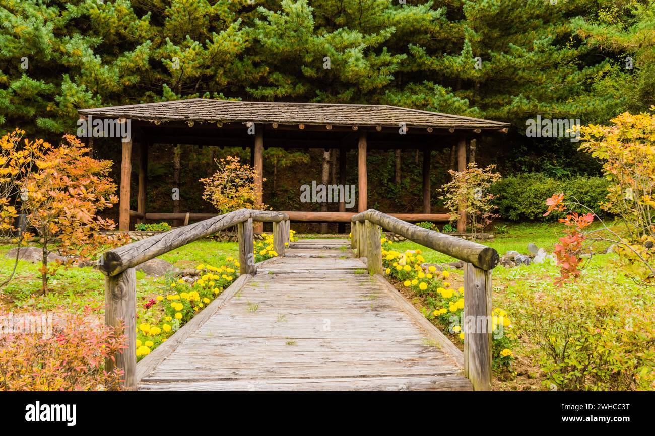 Wooden walkway with wooden post railings leading to a covered rest area ...