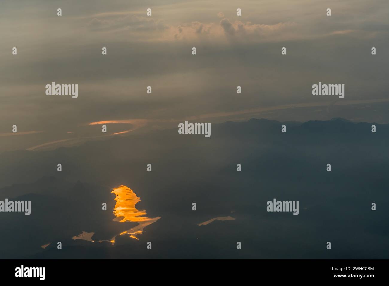 Sun reflecting off lake through dark layer of cloud cover taken from ...