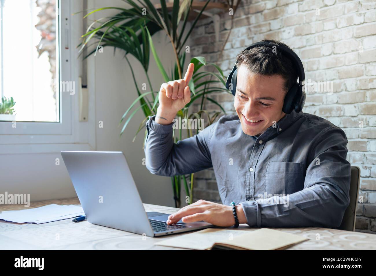 Happy businessman wearing headphones singing song at workplace, funny ...