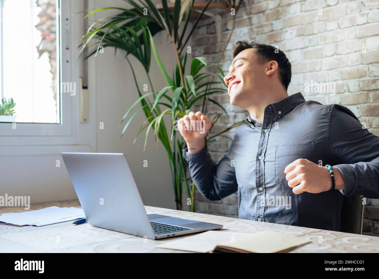 Happy businessman wearing headphones singing song at workplace, funny ...