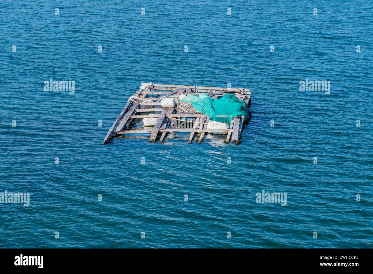Dilapidated wooden raft held afloat with Styrofoam floats in ocean ...