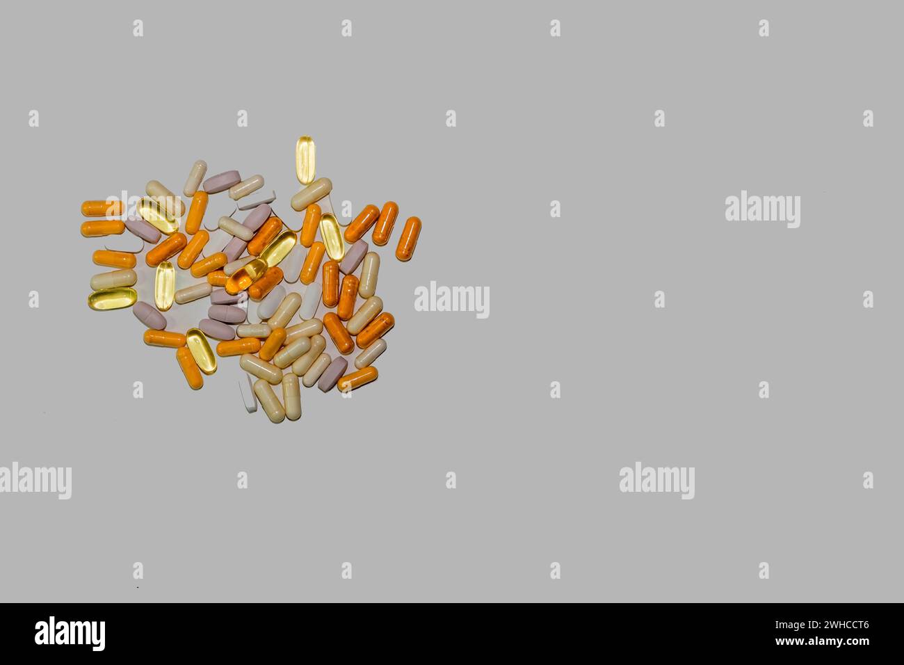 Flat lay of assortment of vitamin supplements on grayish white ...