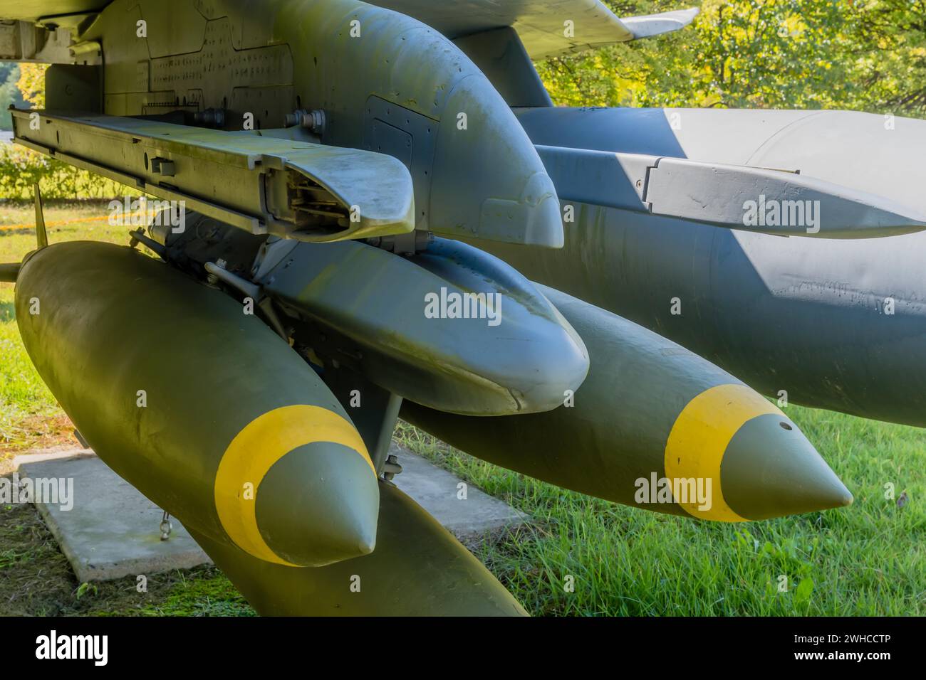 Closeup battery of bombs mounted on port side wing of jet fighter on ...