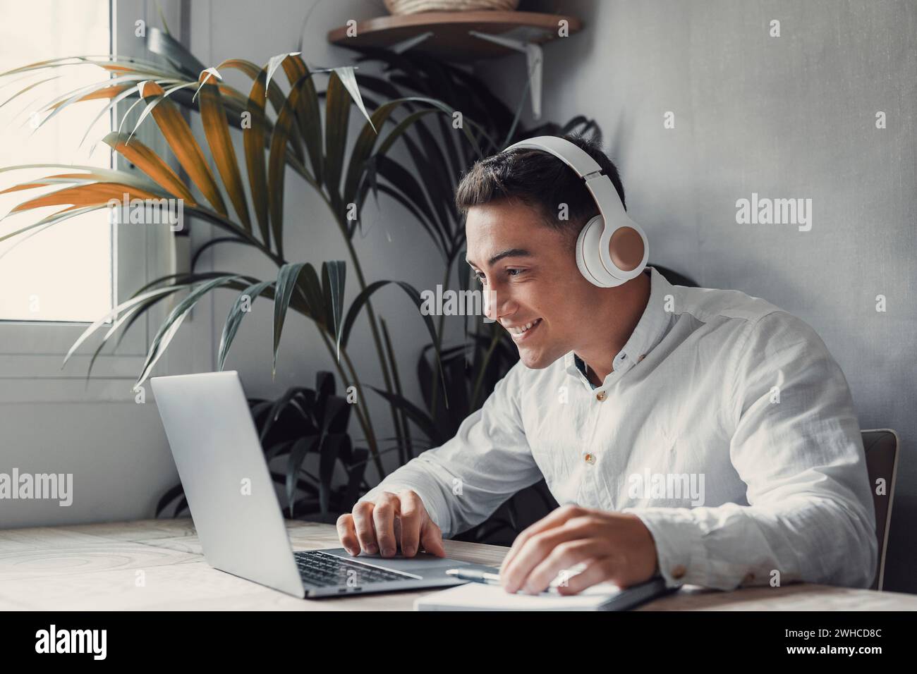 Happy businessman wearing headphones singing song at workplace, funny ...