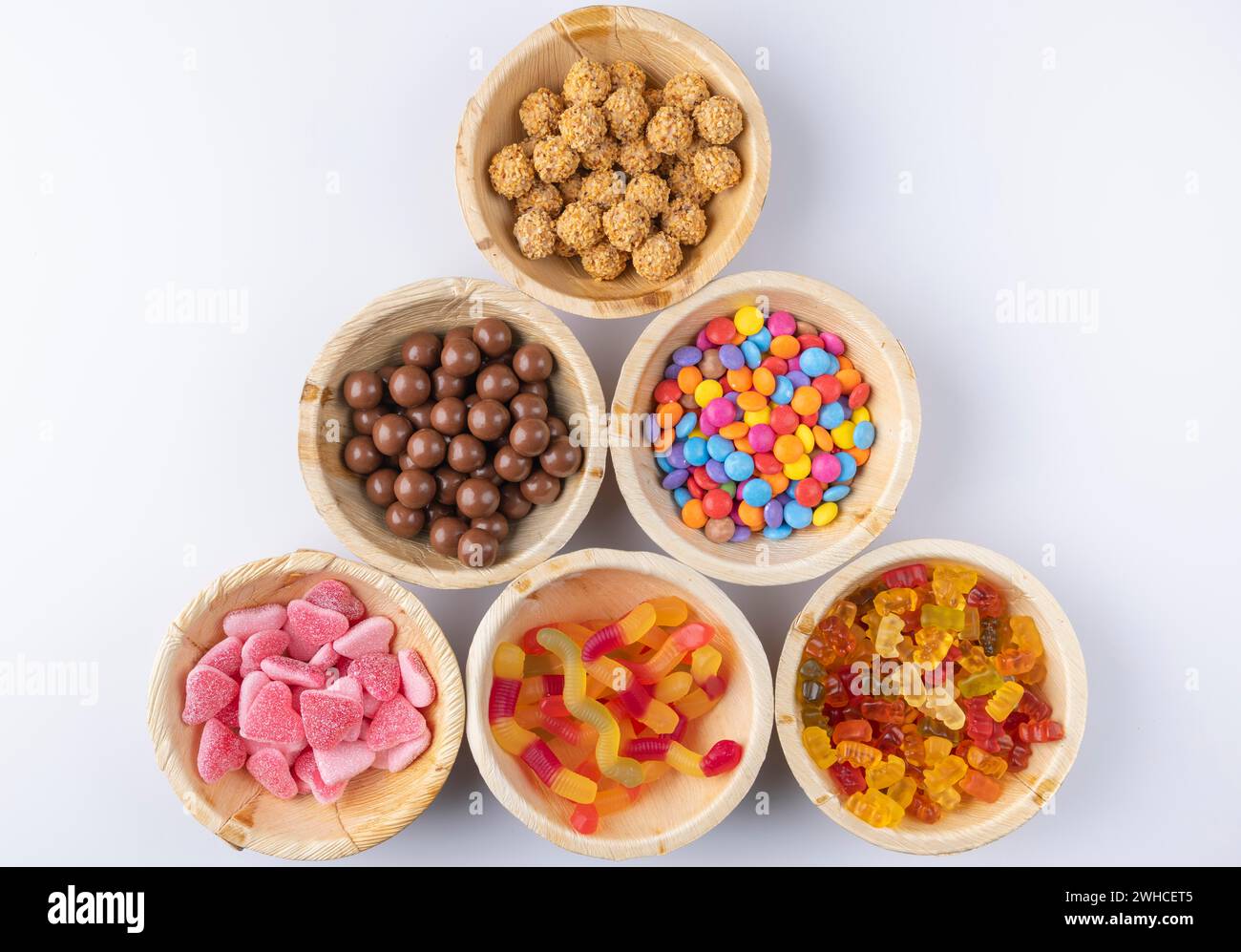 Various sweets arranged in wooden bowls on a white background Stock ...