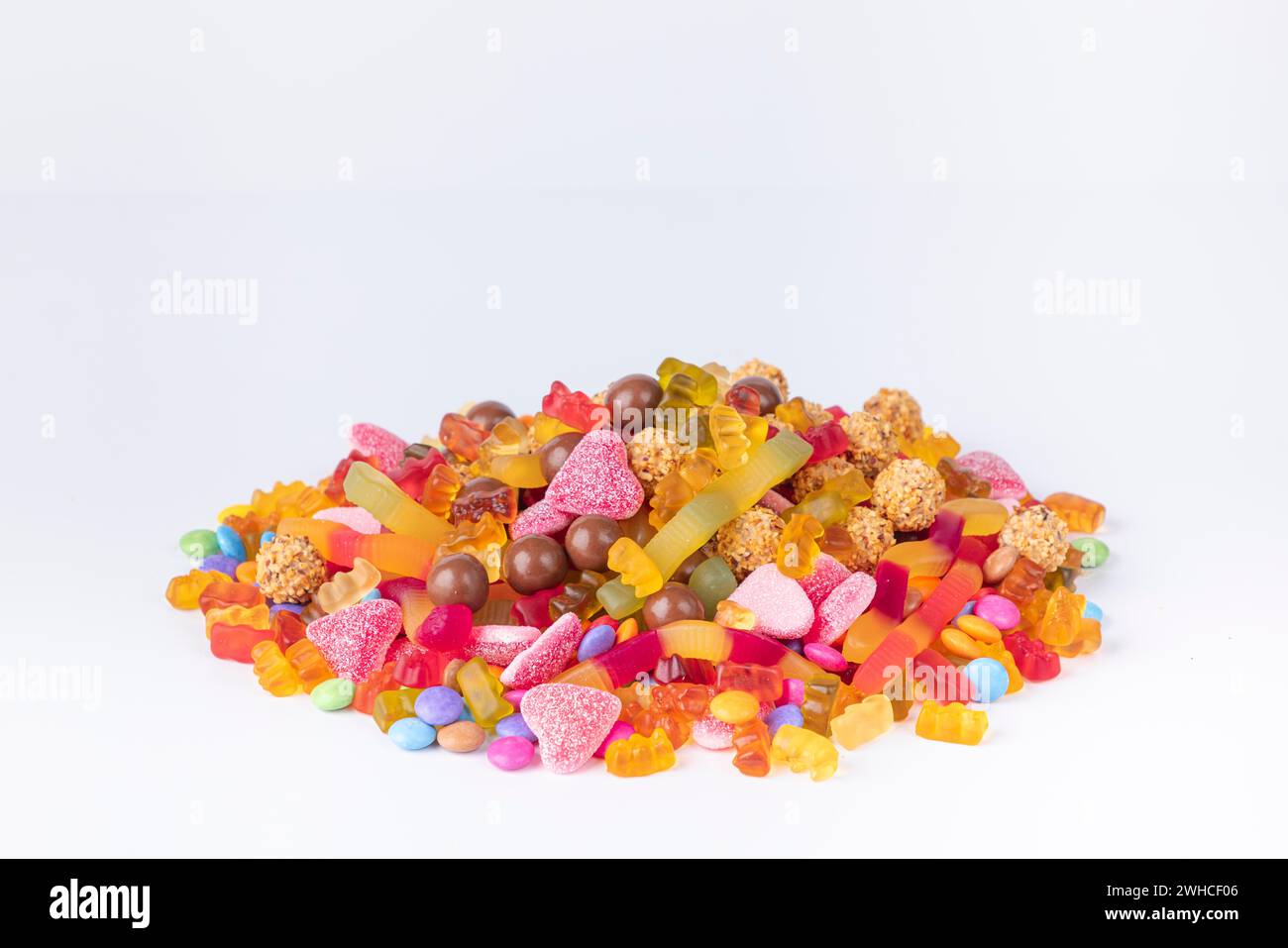 A colourful pile of different sweets on a white background, copy room ...