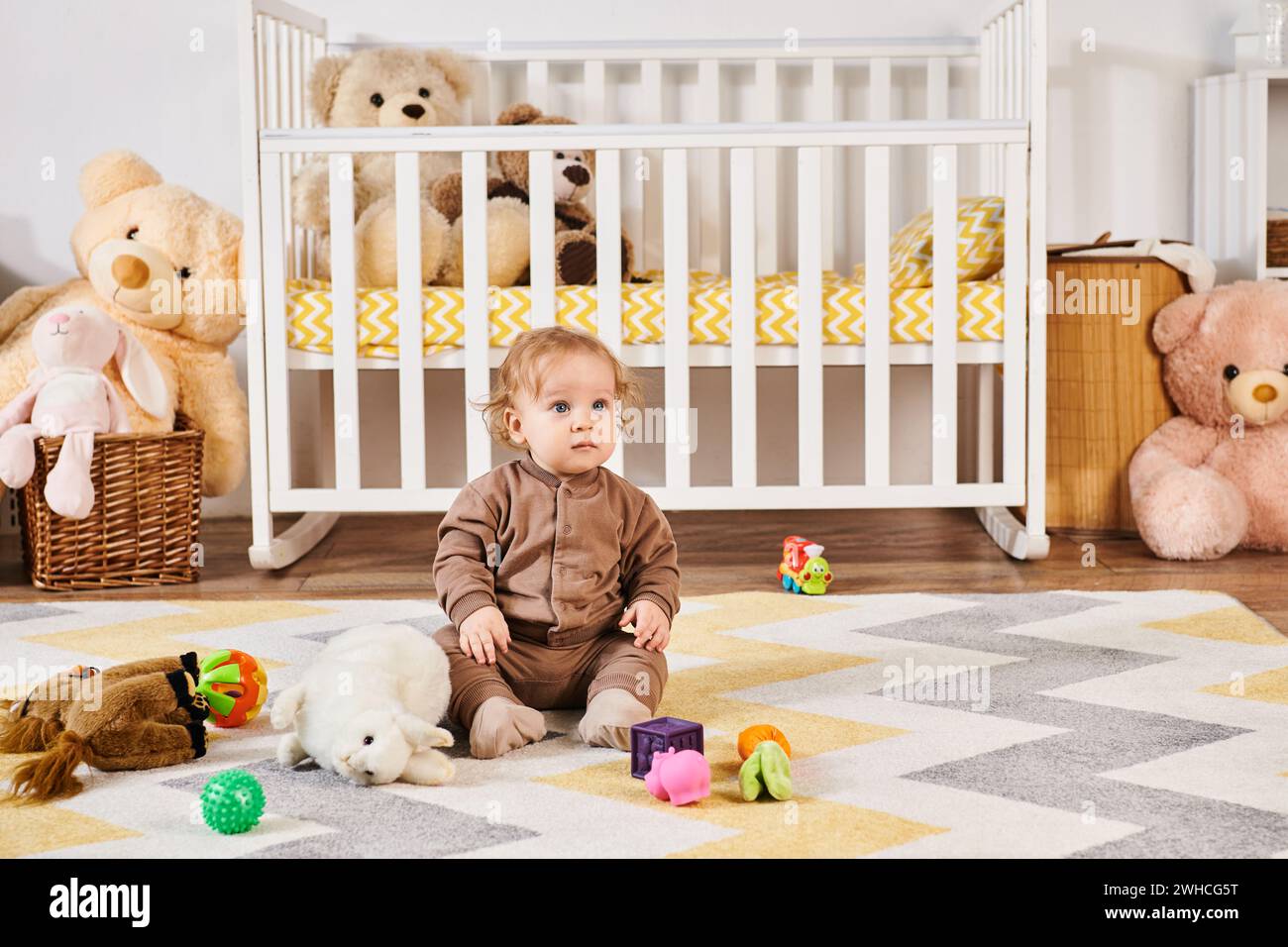 little boy sitting on floor near soft toys and crib in cozy nursery ...
