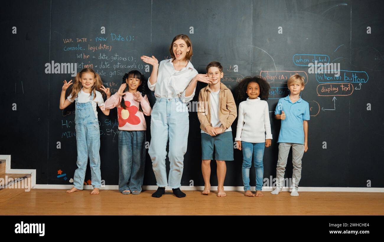 Multicultural student and teacher smiling and waving hand at blackboard ...