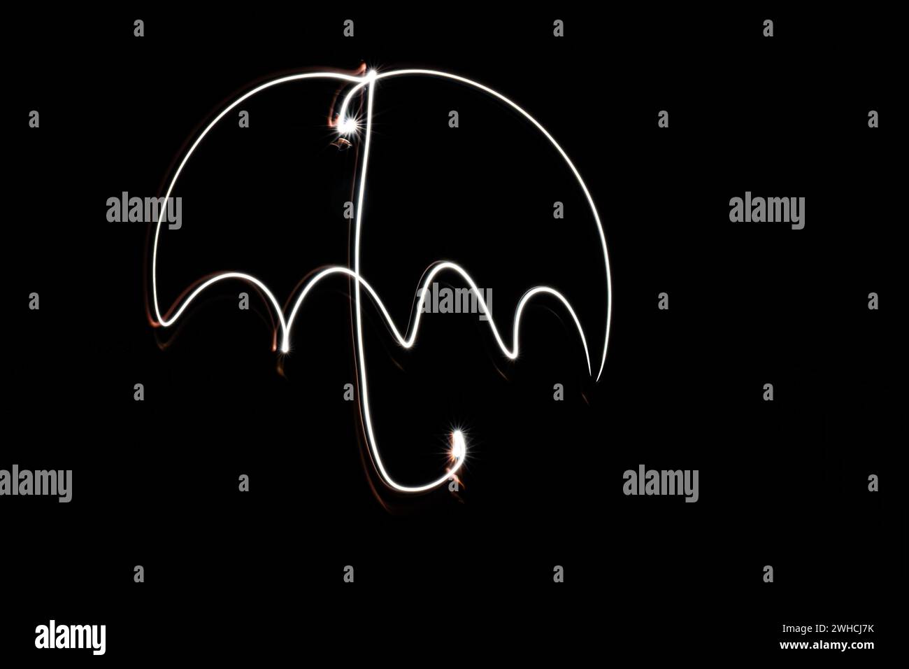 A whimsical light painting forms the silhouette of an umbrella, its ...