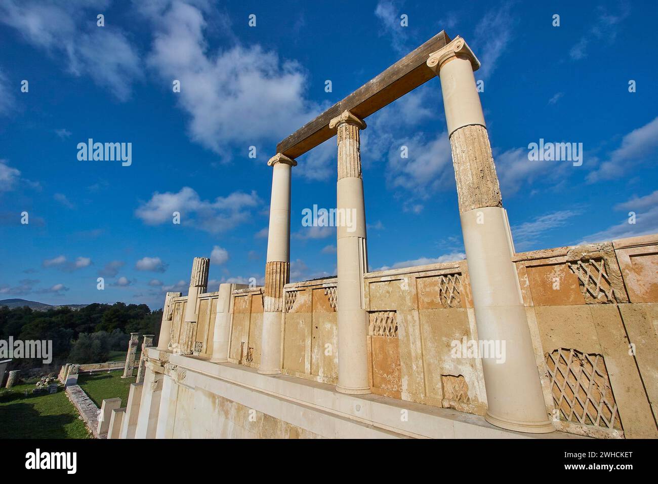 Three ancient columns stand tall against a deep blue sky with fine carvings, Ancient Temple ...