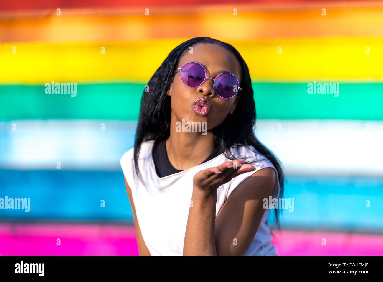 African woman with sunglasses gesturing blowing a kiss in a ...