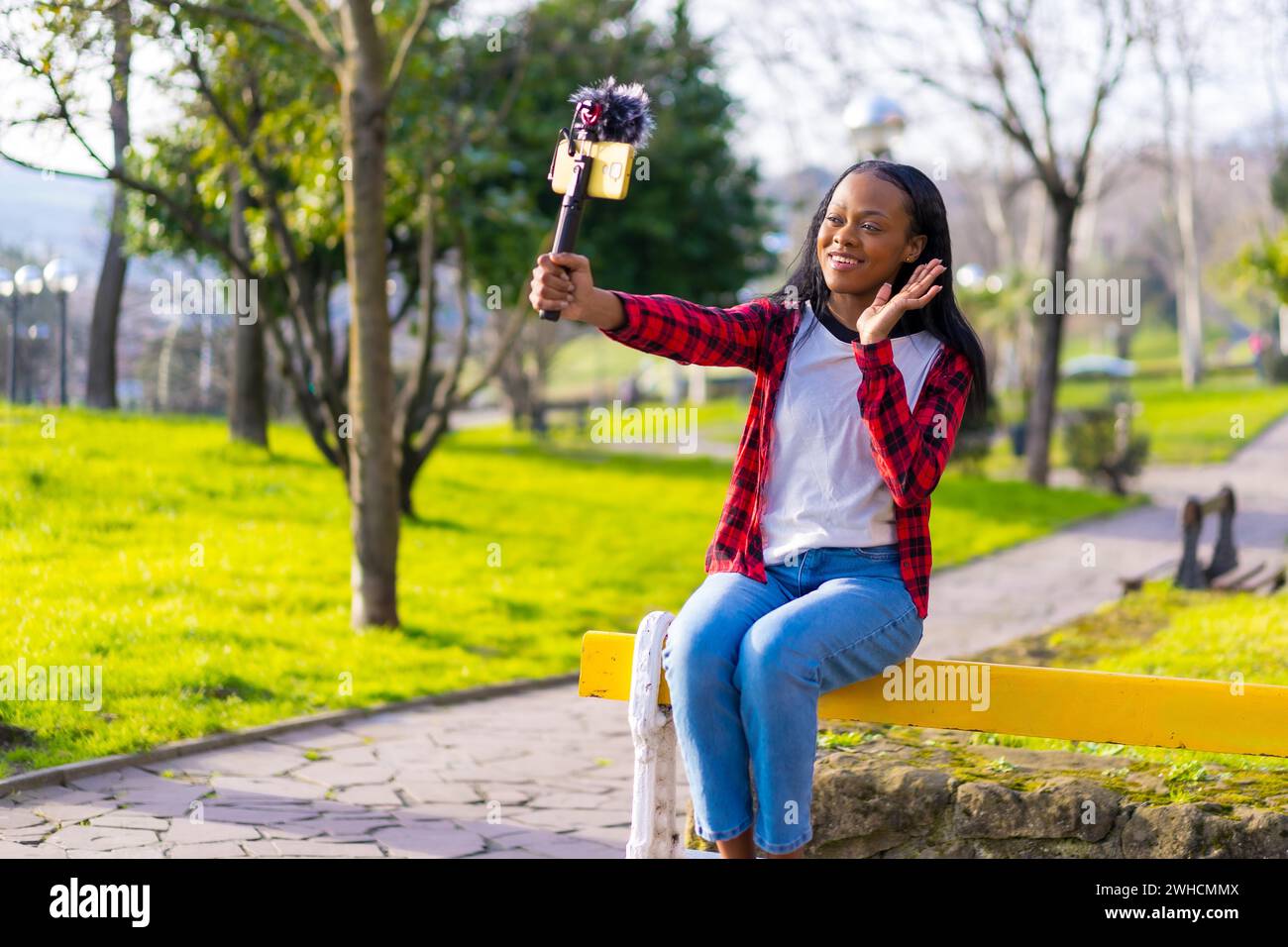Young african vlogger records a video with a mobile in a park Stock ...