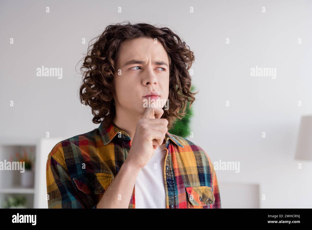 Photo of doubtful unsure guy wear plaid shirt hand arm chin thinking ...