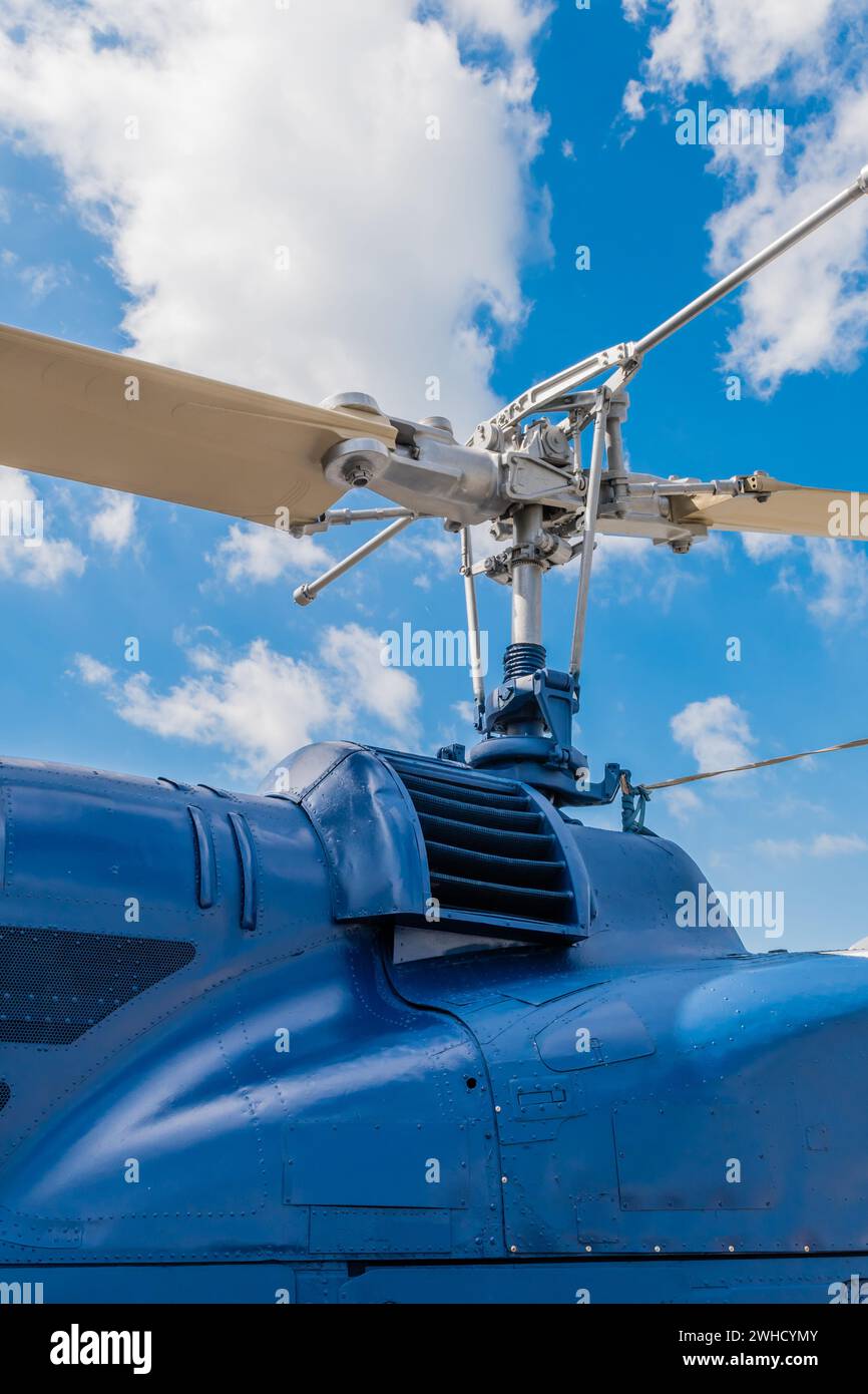 Cowling and rotor assembly on helicopter with blue cloudy sky in ...