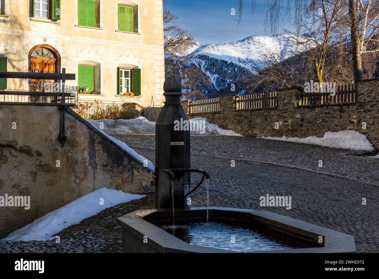 Wooden fountain, house with sgraffito, facade decorations, mountain ...