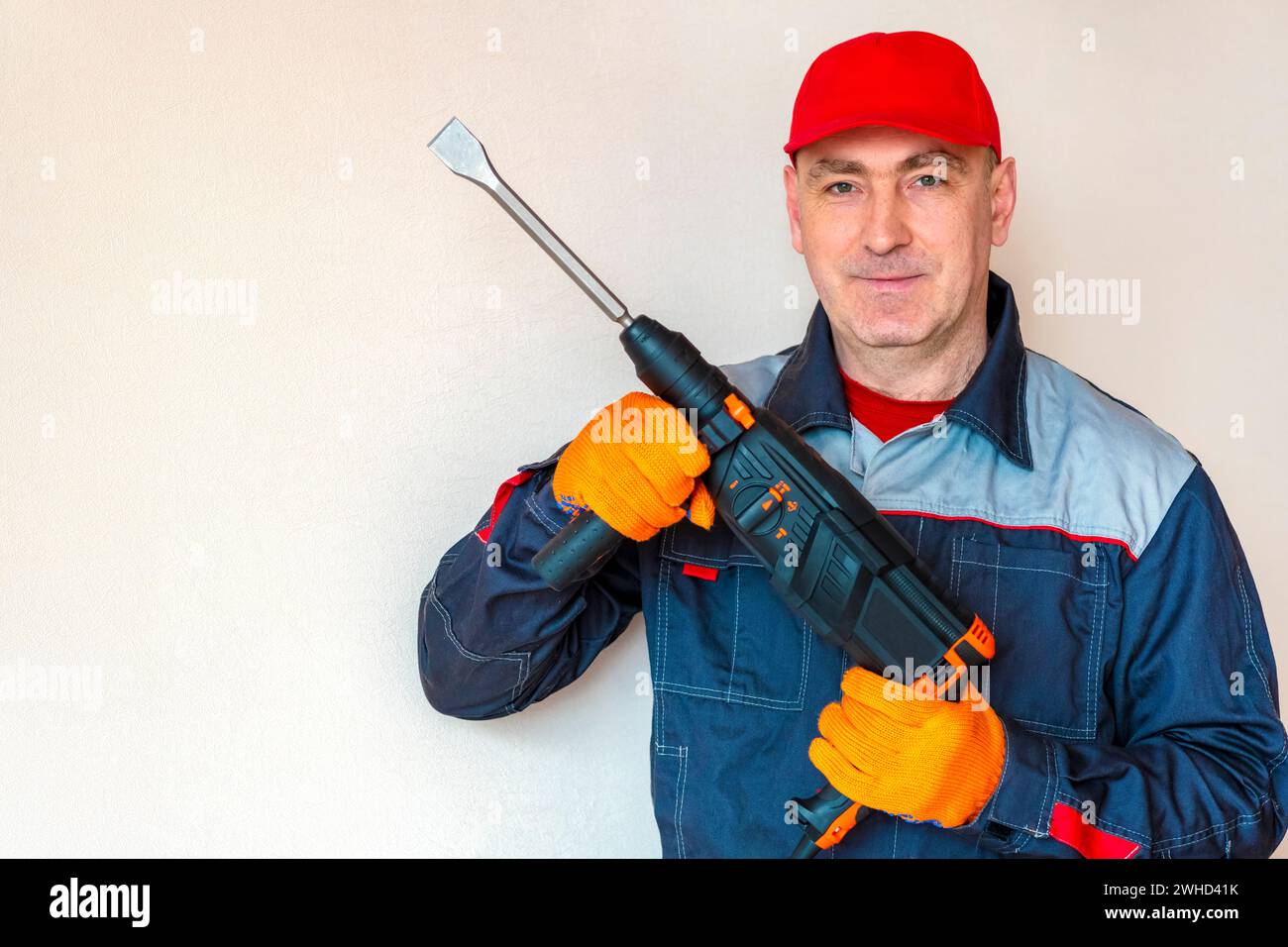 workman with a rotary hammer. worker, professional with hammer drill ...