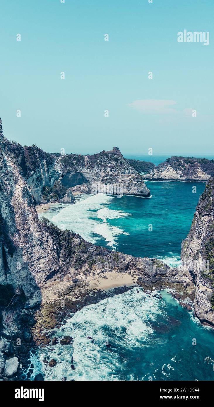 An aerial perspective of a rocky coastline and vivid turquoise waters ...