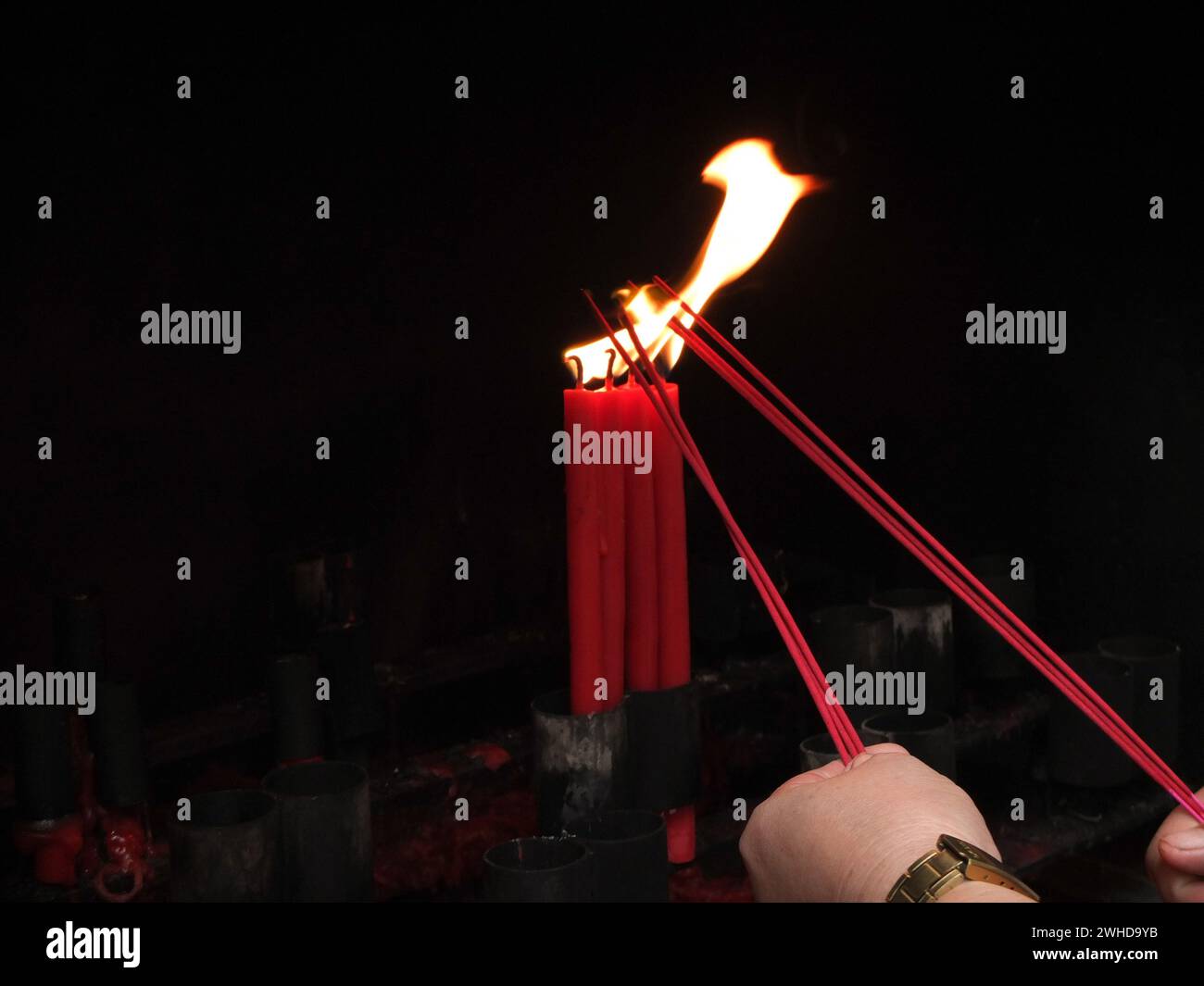 View of a hand lighting an incense sticks. Filipino-Chinese in the ...