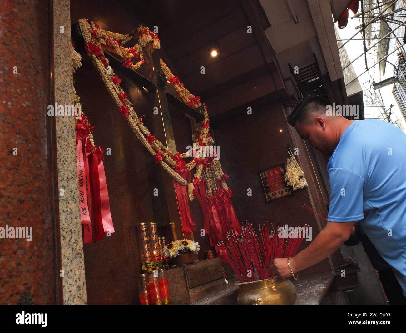 A man seen lighting an incense stick. Filipino-Chinese in the ...