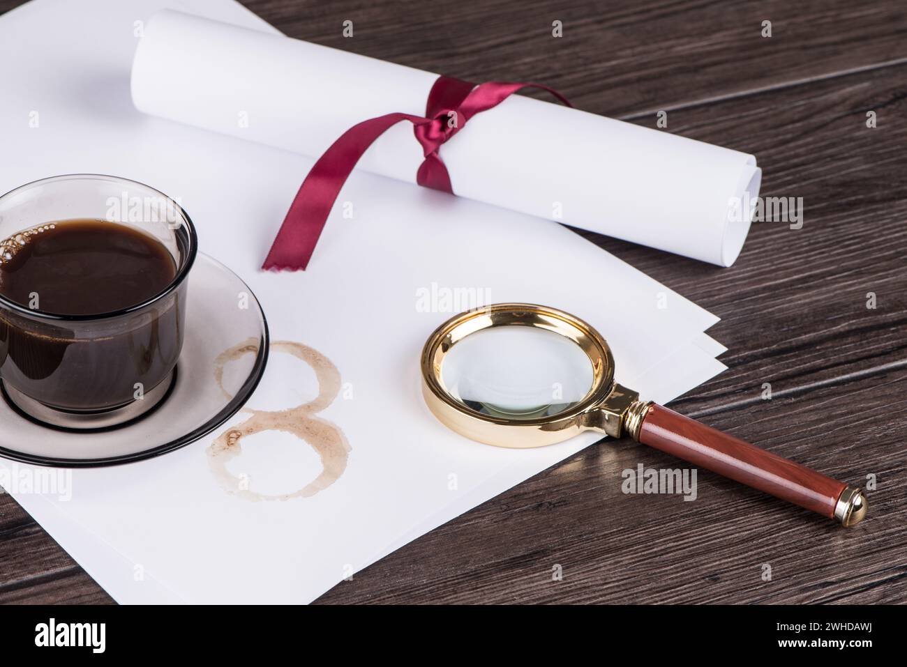 Coffee cup, paper sheets and detective magnifying glass Stock Photo - Alamy