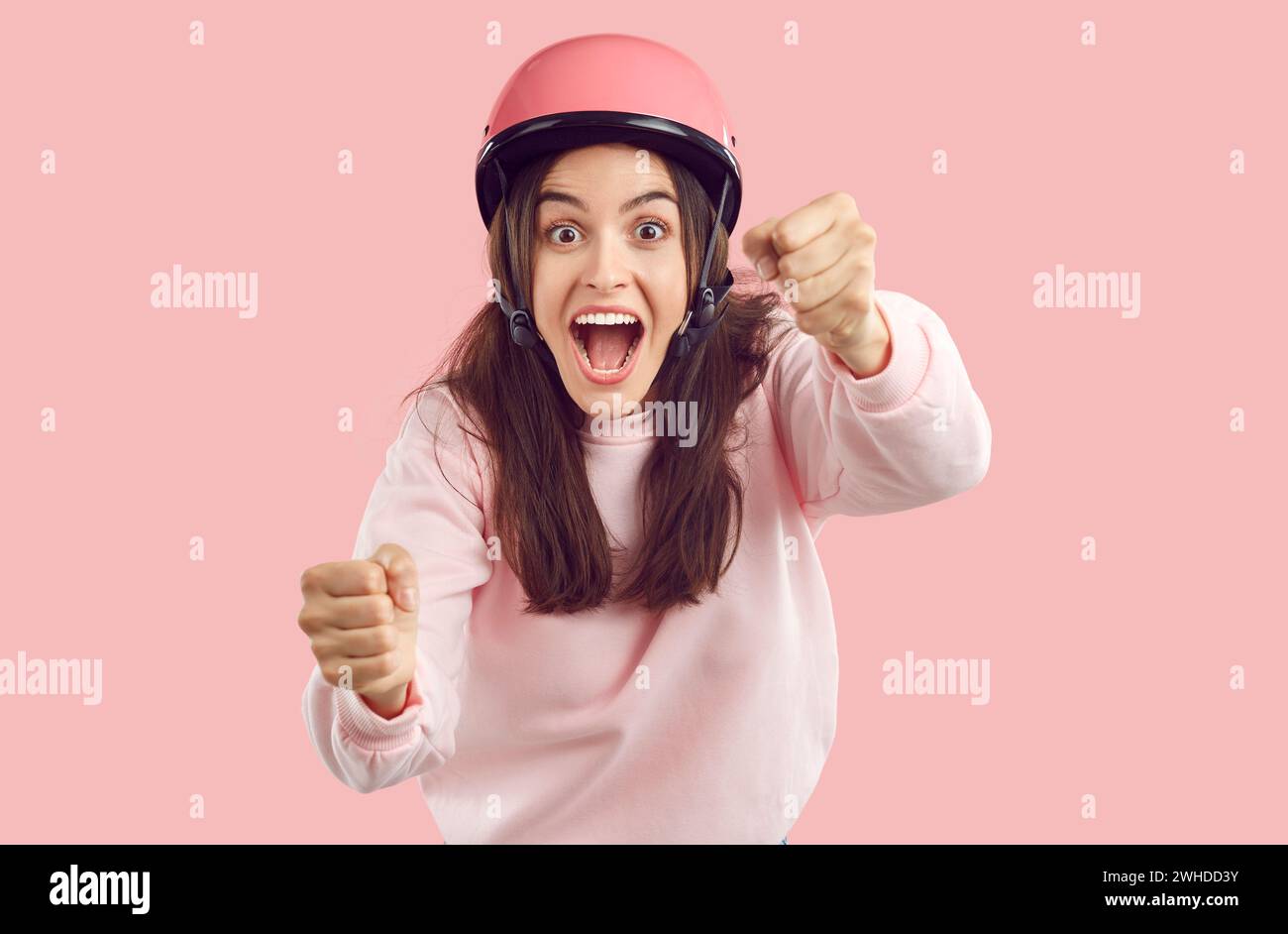 Funny woman in pink helmet with excited or scared face expression ...
