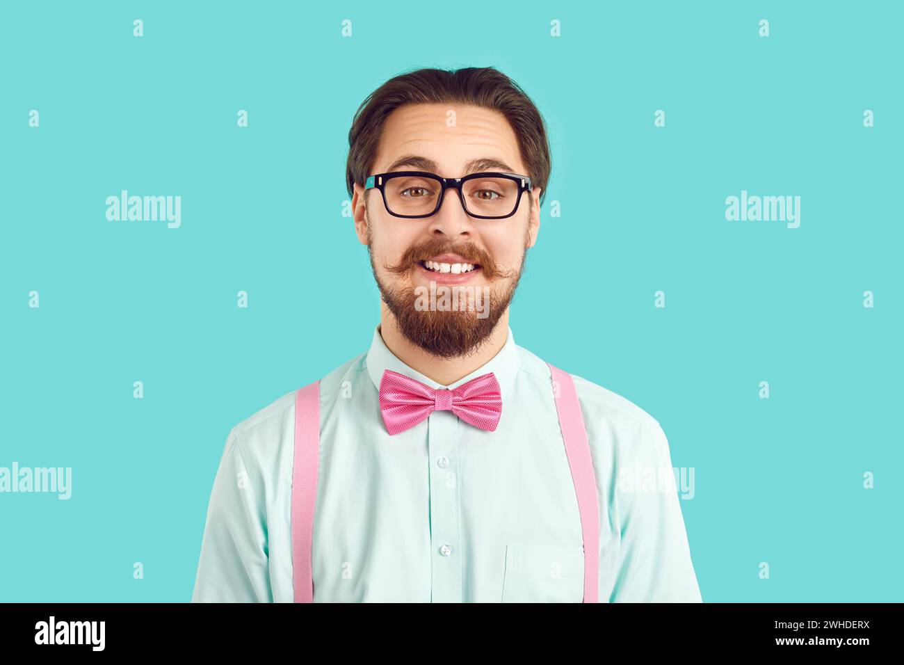 Portrait of funny male nerd hipster in stylish colored clothes on light ...