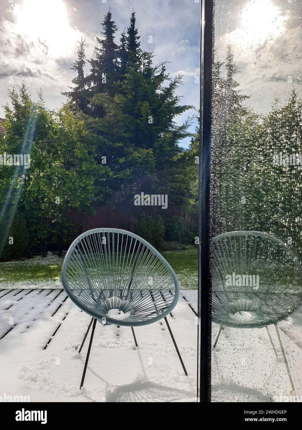 View through the open window across the terrace in the sunlight covered ...