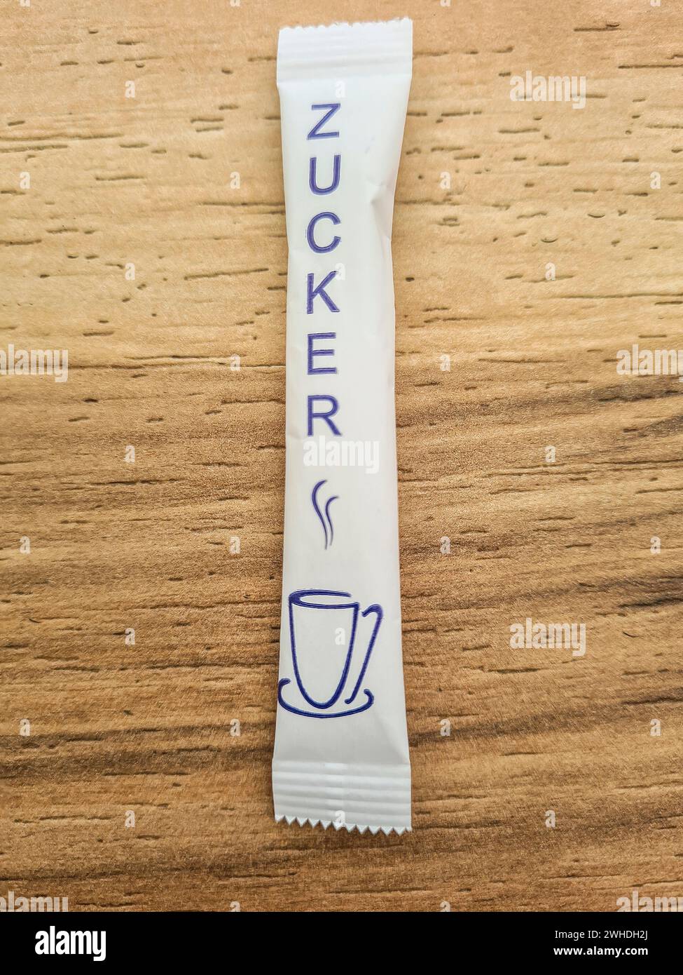 A white sachet bag with the inscription sugar and a picture of a cup ...