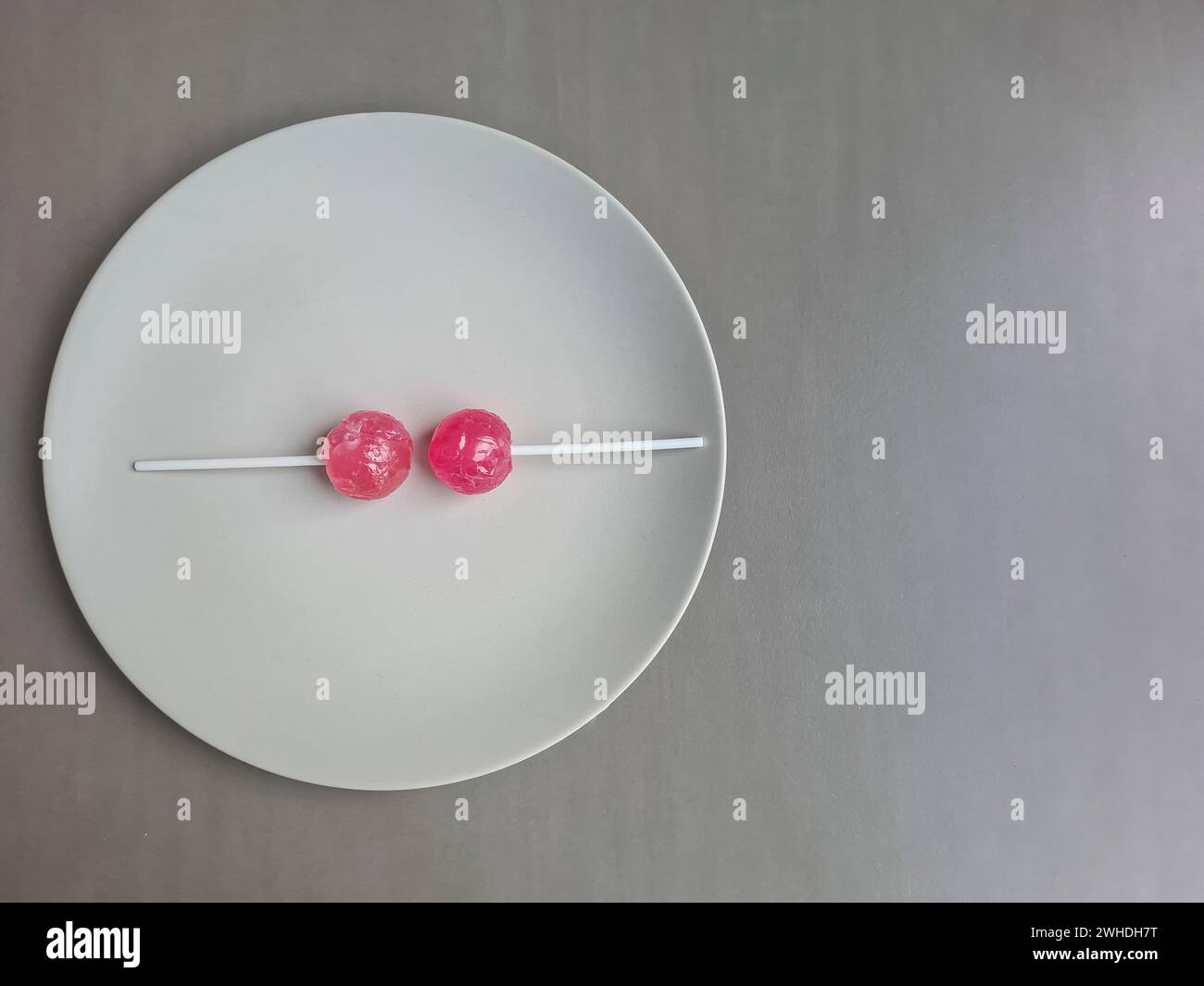 Two light red strawberry-flavored lollipops, lollipops with a white ...