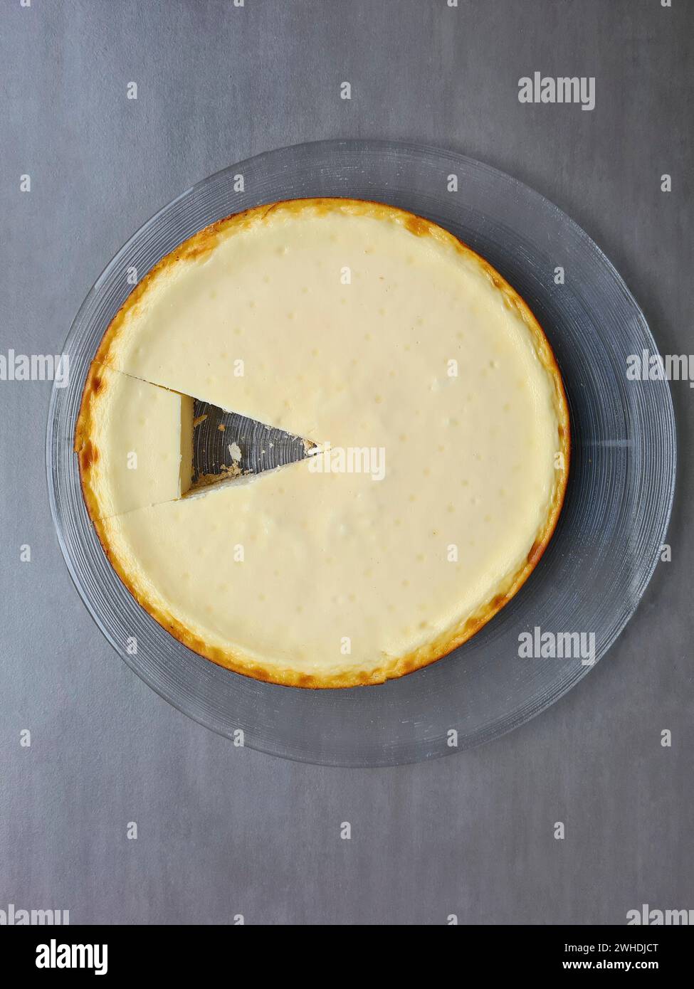 Round, smooth, moist cheesecake with a triangle in the cake Stock Photo ...
