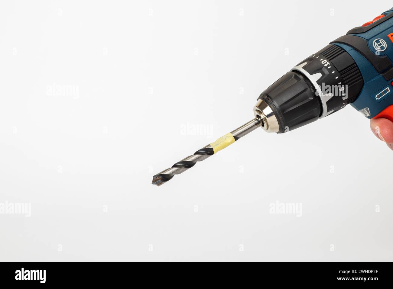 Cordless drill driver, masonry drill bit wrapped with adhesive tape to ...