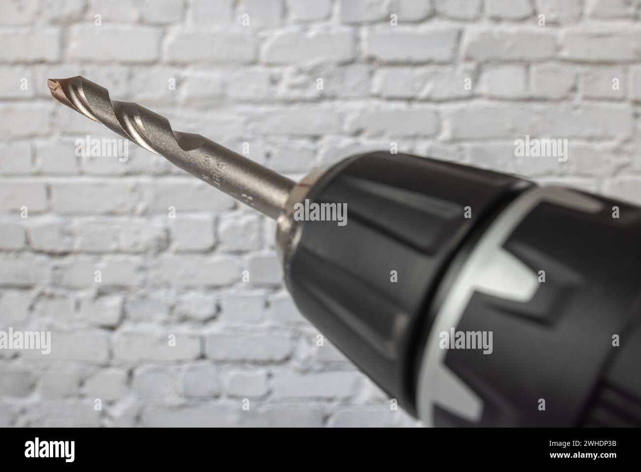 Cordless drill with inserted masonry drill bit, detail, background ...
