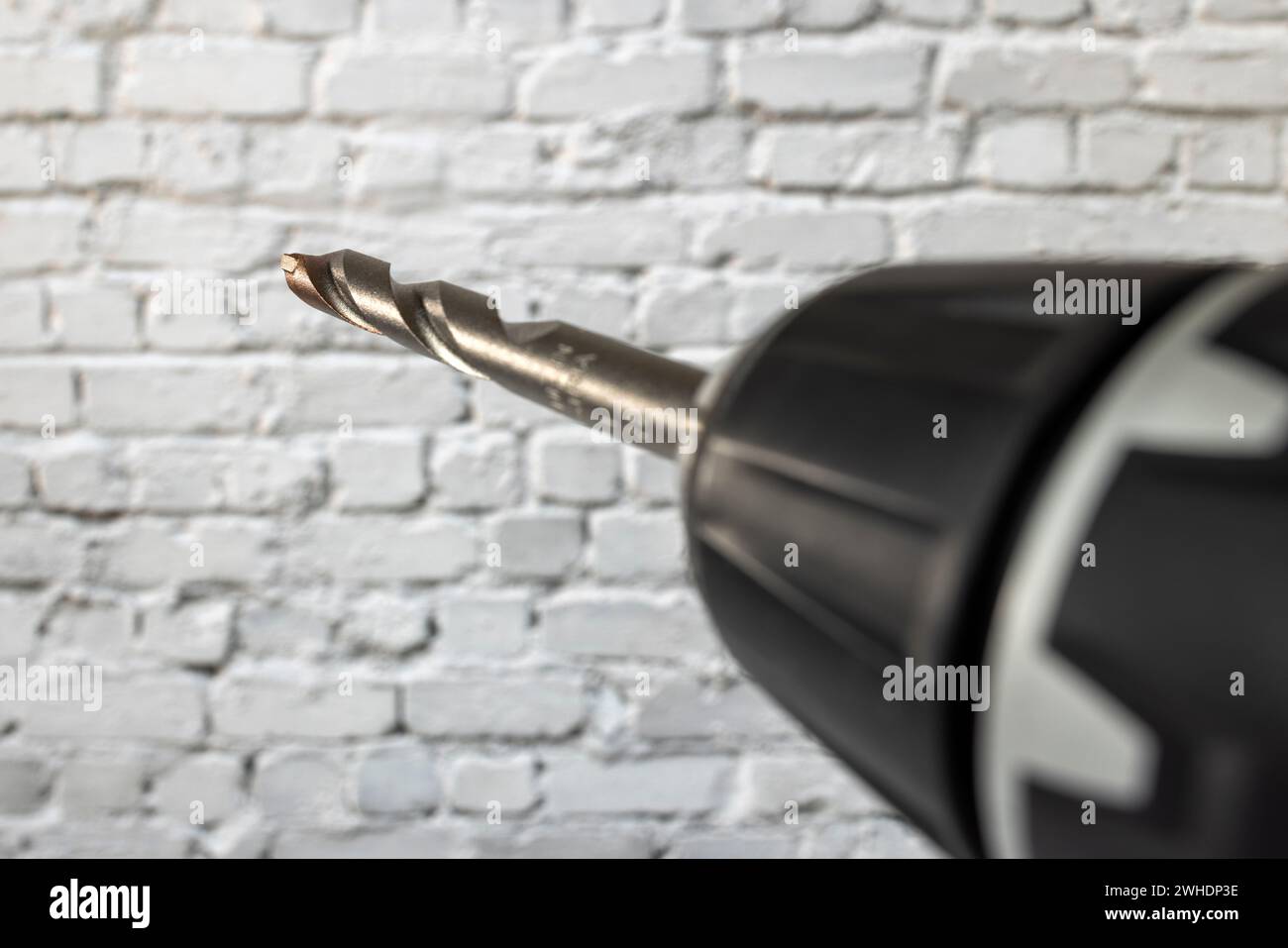 Cordless drill with inserted masonry drill bit, detail, background ...