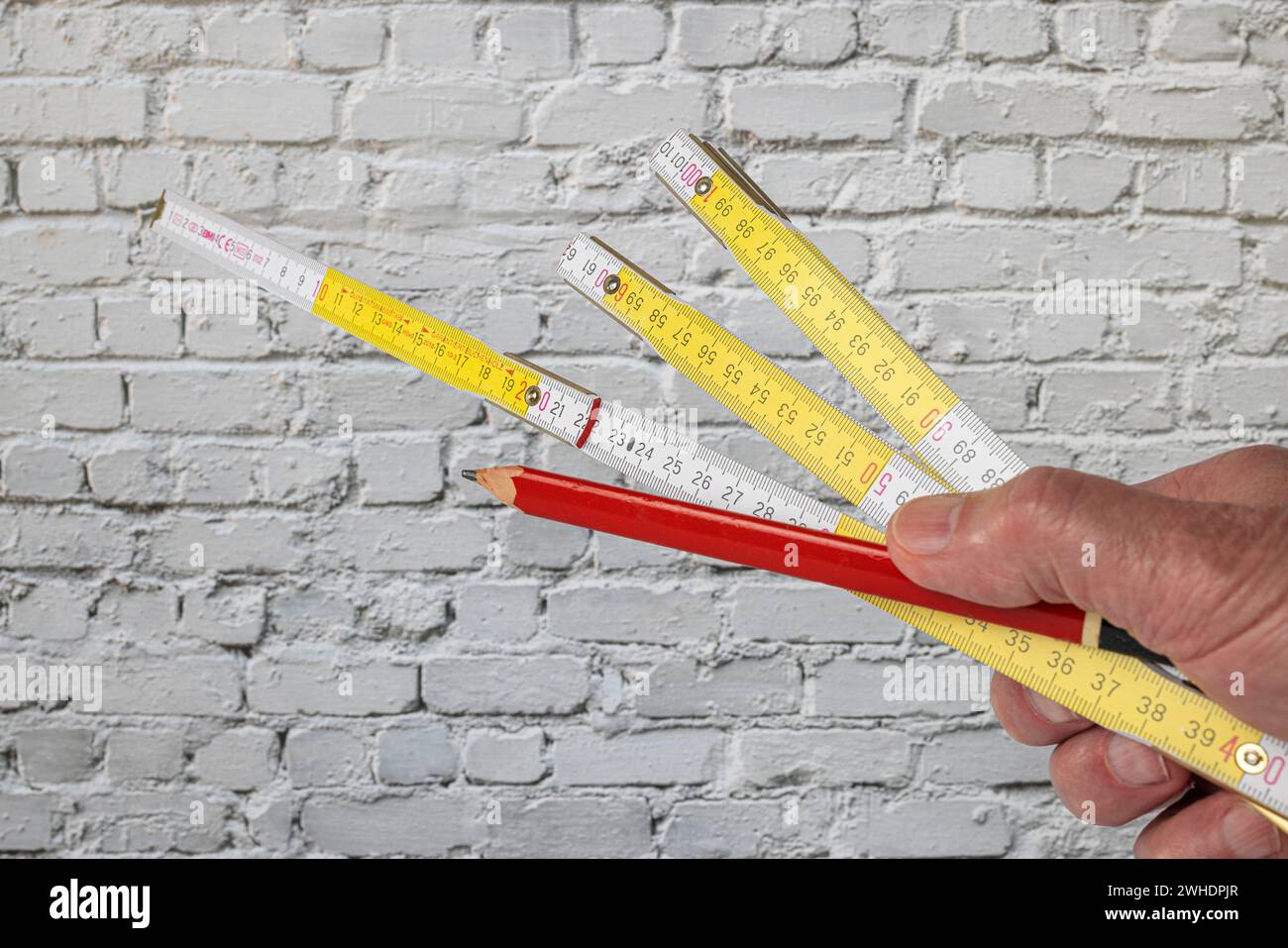 Man's hand holding folding rule with millimeter and centimeter ...