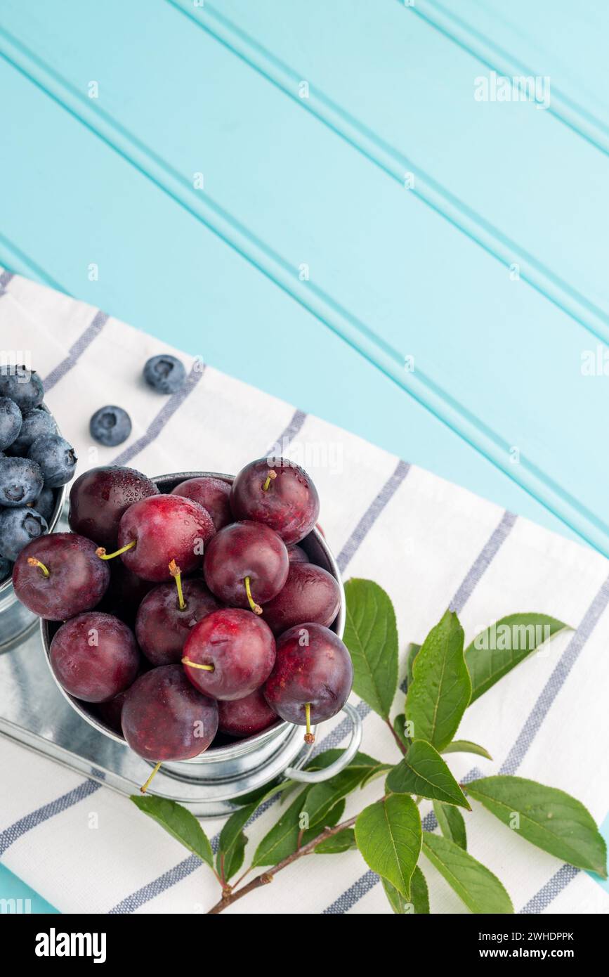 Plums in small metal bucket Stock Photo - Alamy