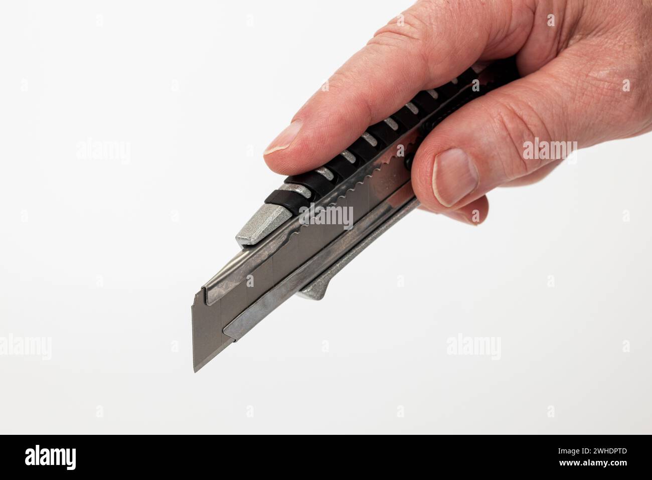 Man's hand holding cutter knife with 18 mm snap-off blade, die-cast ...