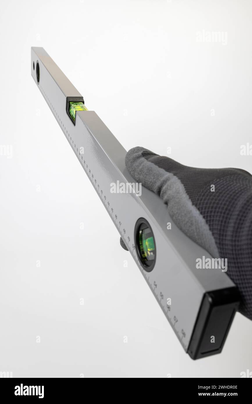 Man's hand with work glove holding spirit level, gray, white background ...