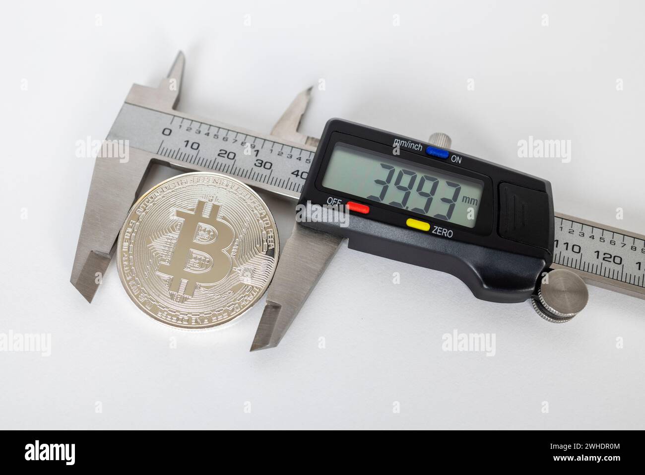 Electronic caliper measures the diameter of a Bitcoin coin, white ...