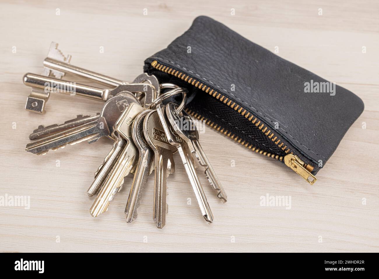 Many keys on key ring with key case, wood background Stock Photo - Alamy