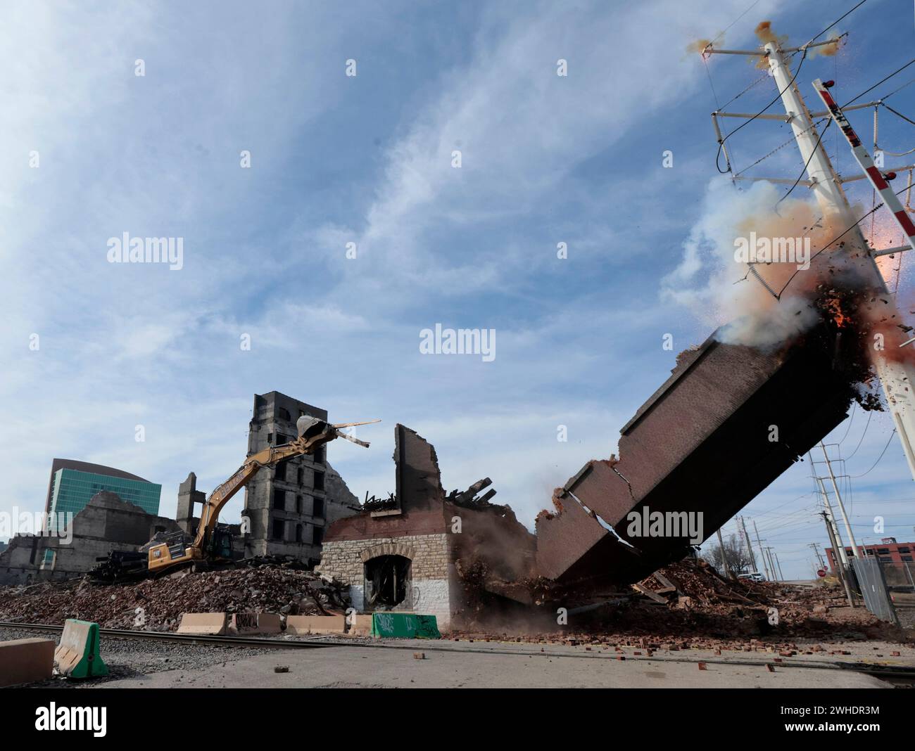 A brief explosion occurs as wrecking crews knock a brick wall into an ...