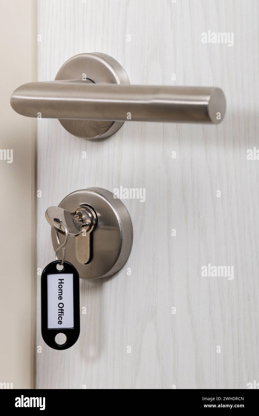 Key with black key fob inserted in the door lock, labeled 'Home Office ...