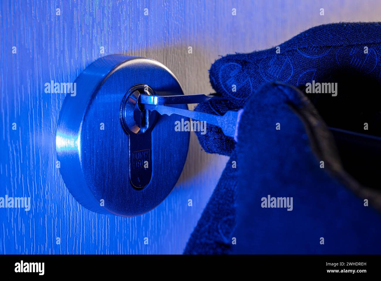 Burglar opens cylinder lock with lockpicking tool, man's hand with ...