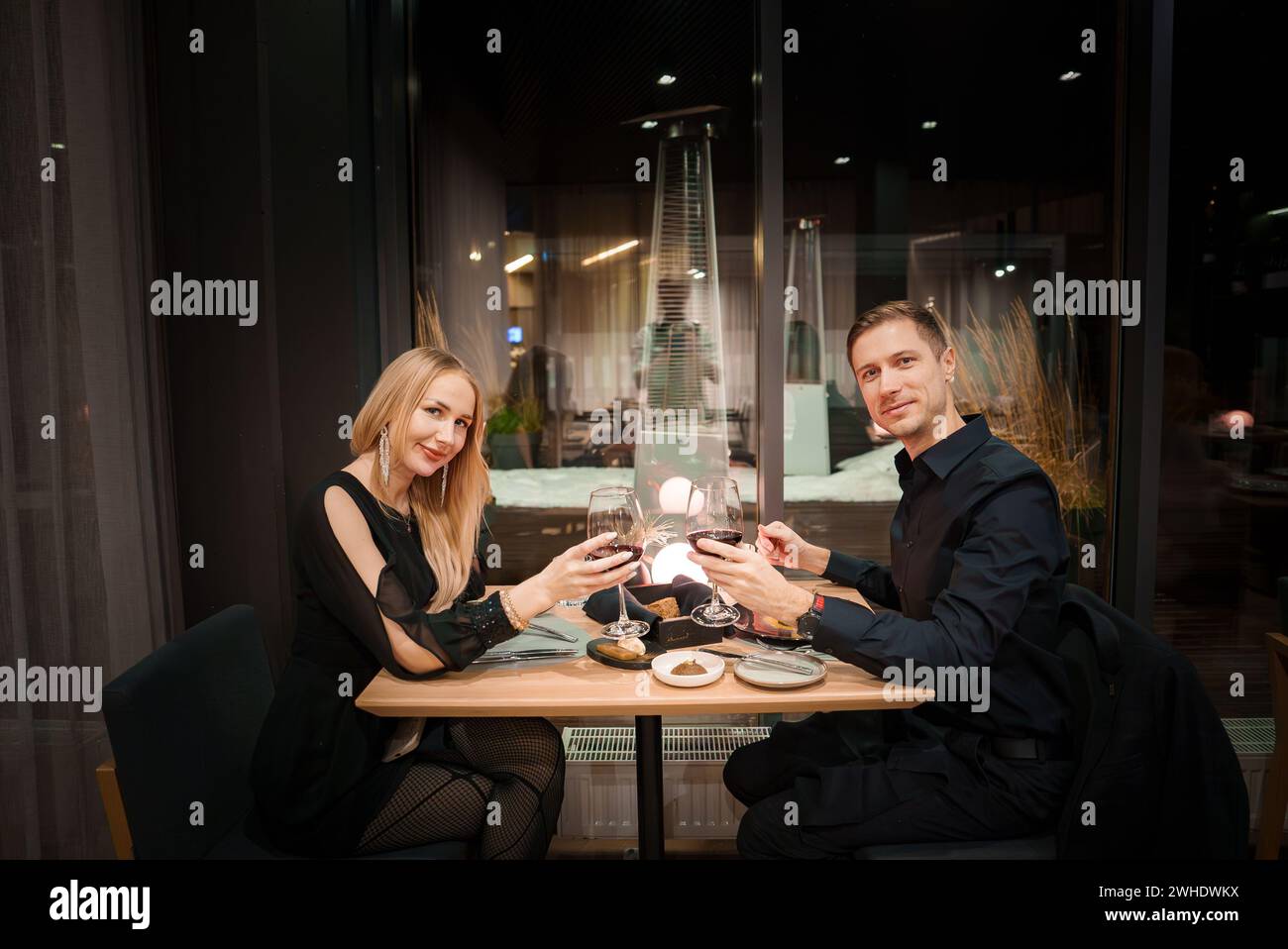 Elegant Couple Toasting with Red Wine in Upscale Restaurant at Night ...