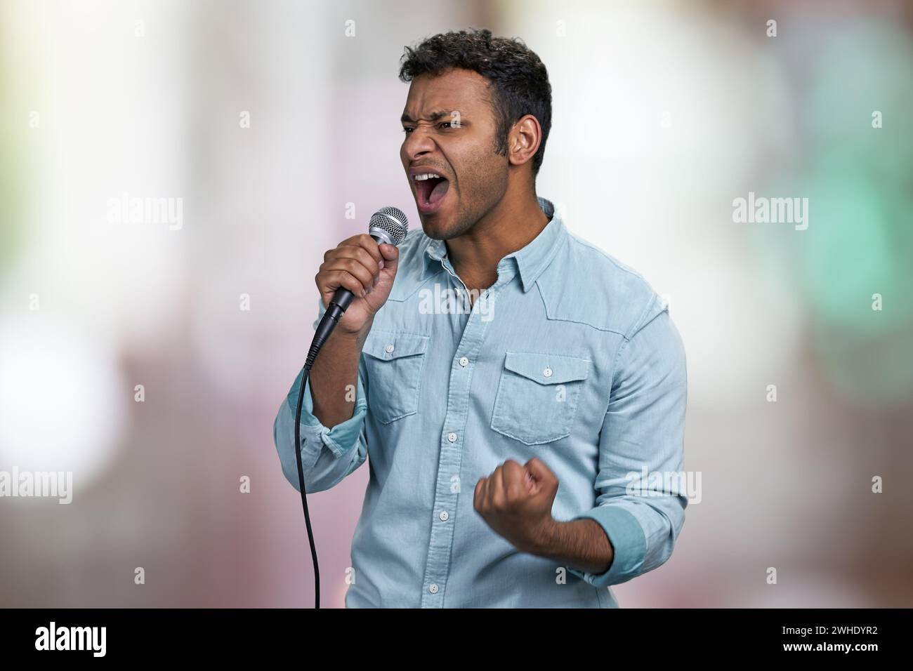 Passionate male singer performing favorite song. Abstract bokeh ...