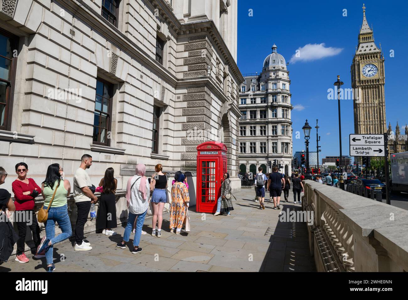 Tourists queuing to take a photo with the iconic K2 red phone box, with ...