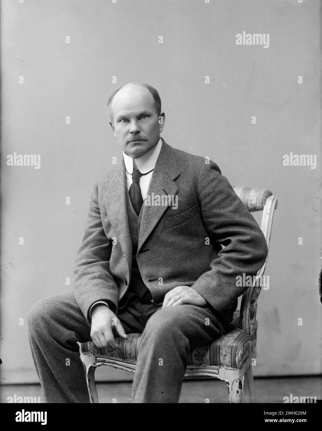 Portrait of Finnish Sculptor Eemil Halonen, sitting on a chair wearing ...