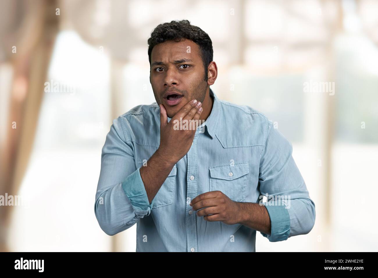 Young handsome indian man is preening before date. Blur interior ...