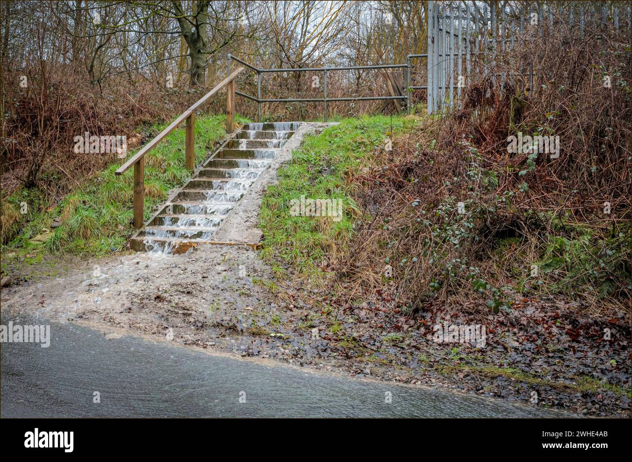 Water flooding down some wooden steps off a railway line due to ...